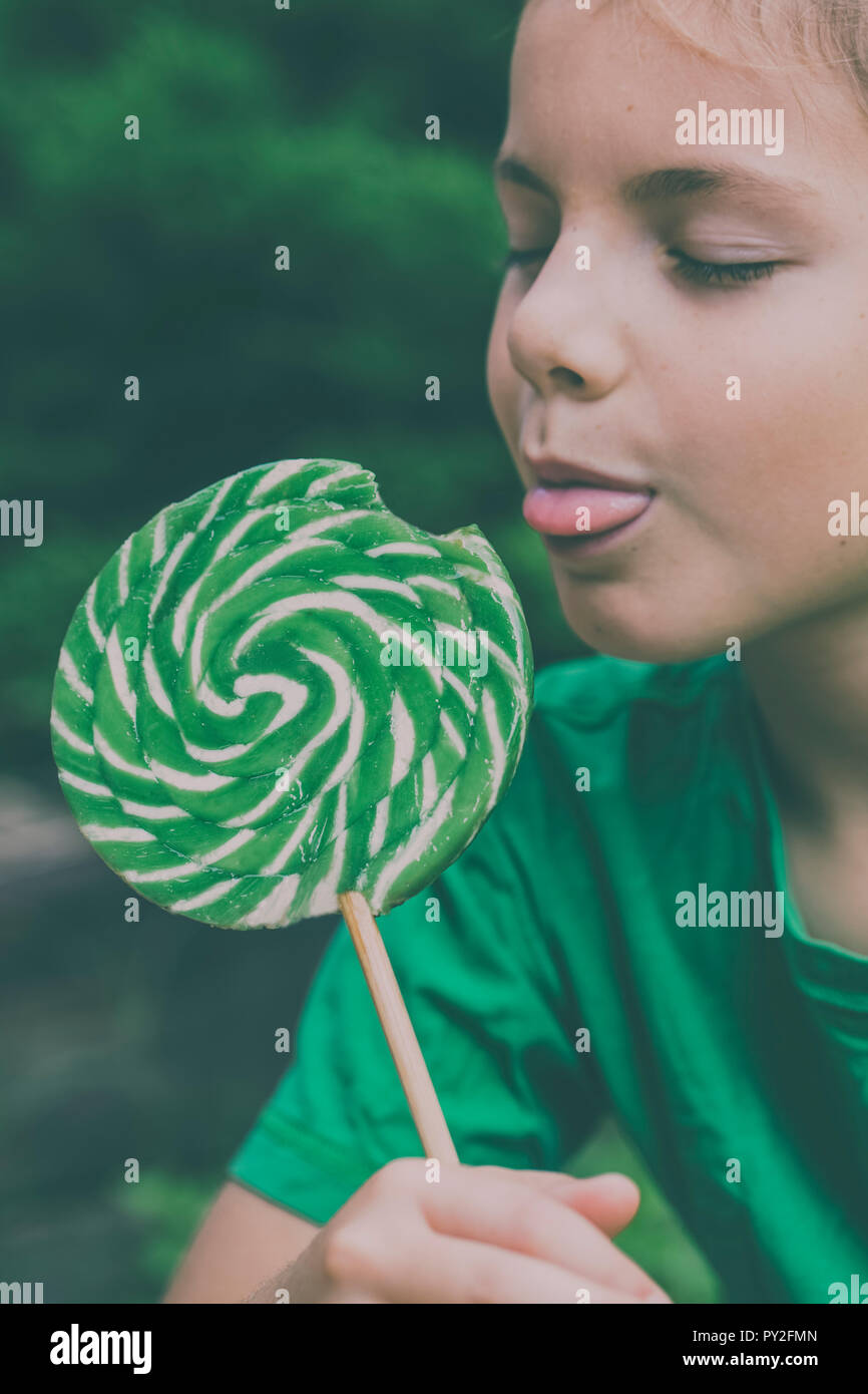 Boy eating a lollipop Stock Photo - Alamy