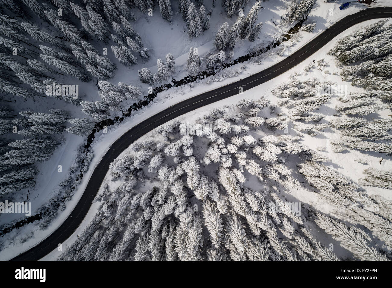 Aerial view on a road winding through snow covered trees, Altenmarkt ...