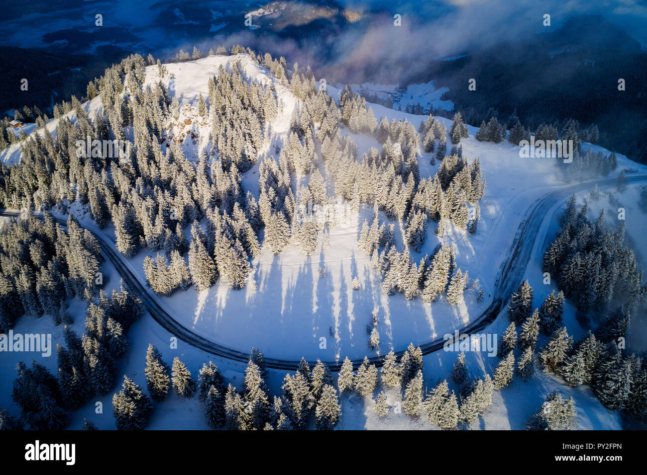 Aerial view on a road winding through snow covered trees, Altenmarkt ...
