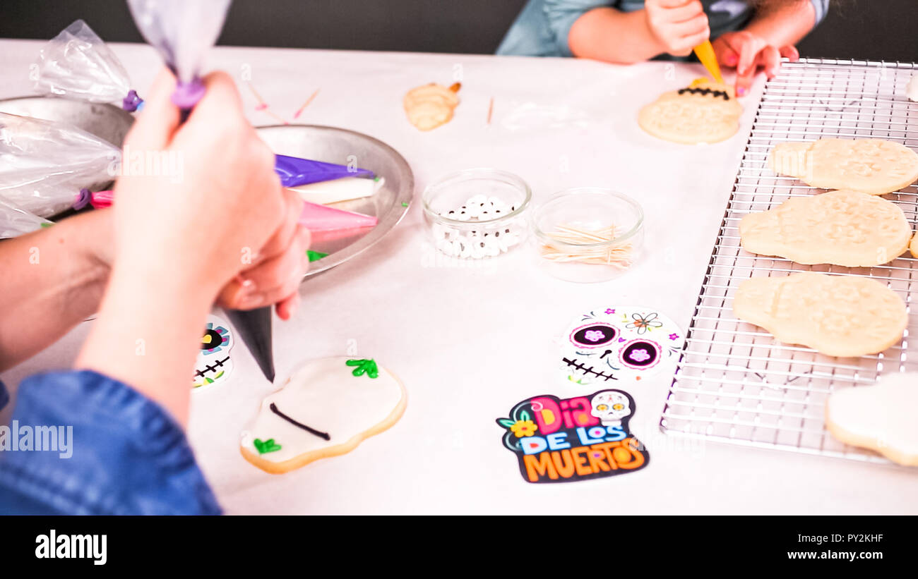 Step by step. Mother and daughter decorating sugar skull cookies with ...