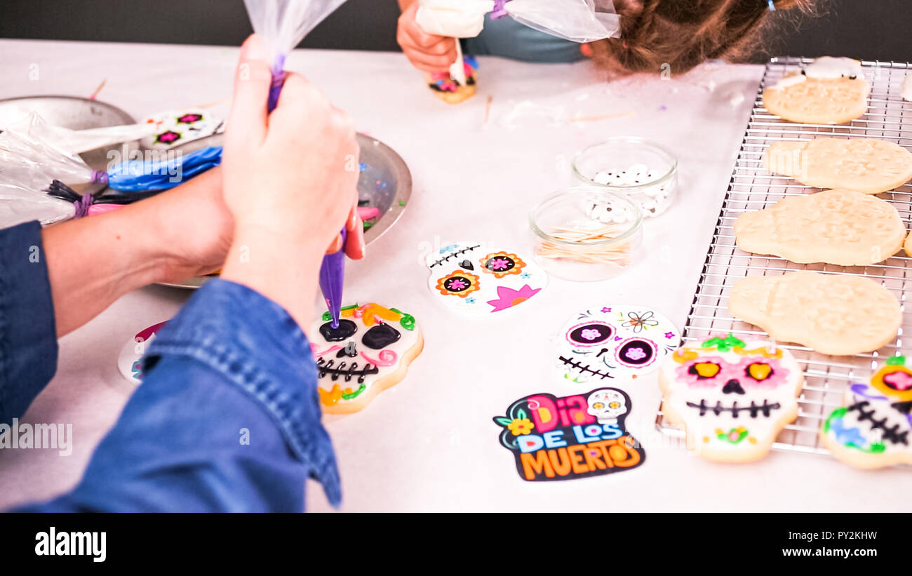Step by step. Mother and daughter decorating sugar skull cookies with ...