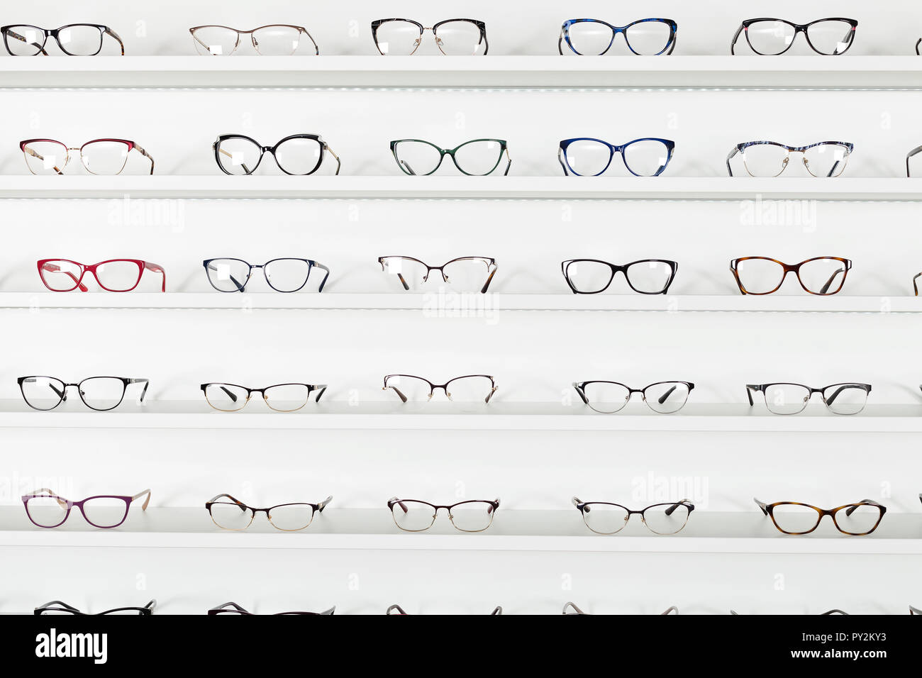 Fashionable corrective eye glasses on a shelf in optical store Stock ...