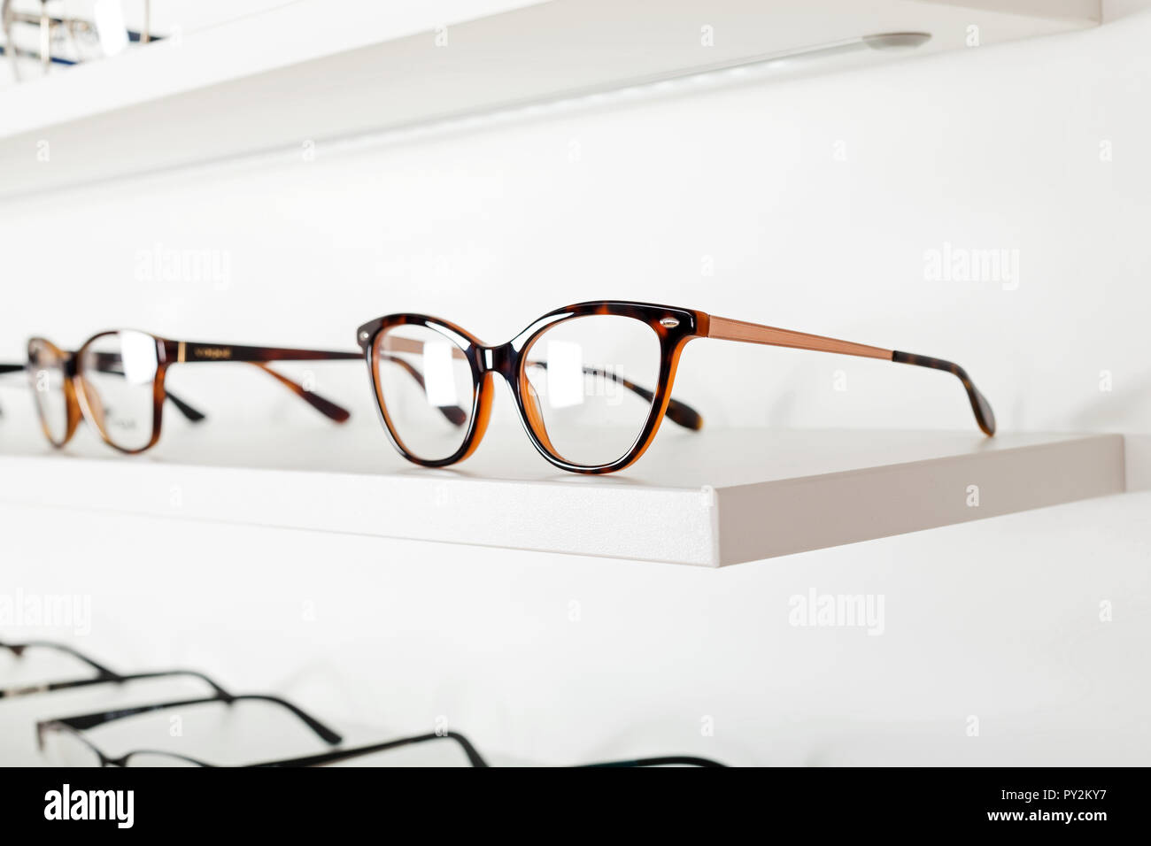Fashionable corrective eye glasses on a shelf in optical store Stock ...