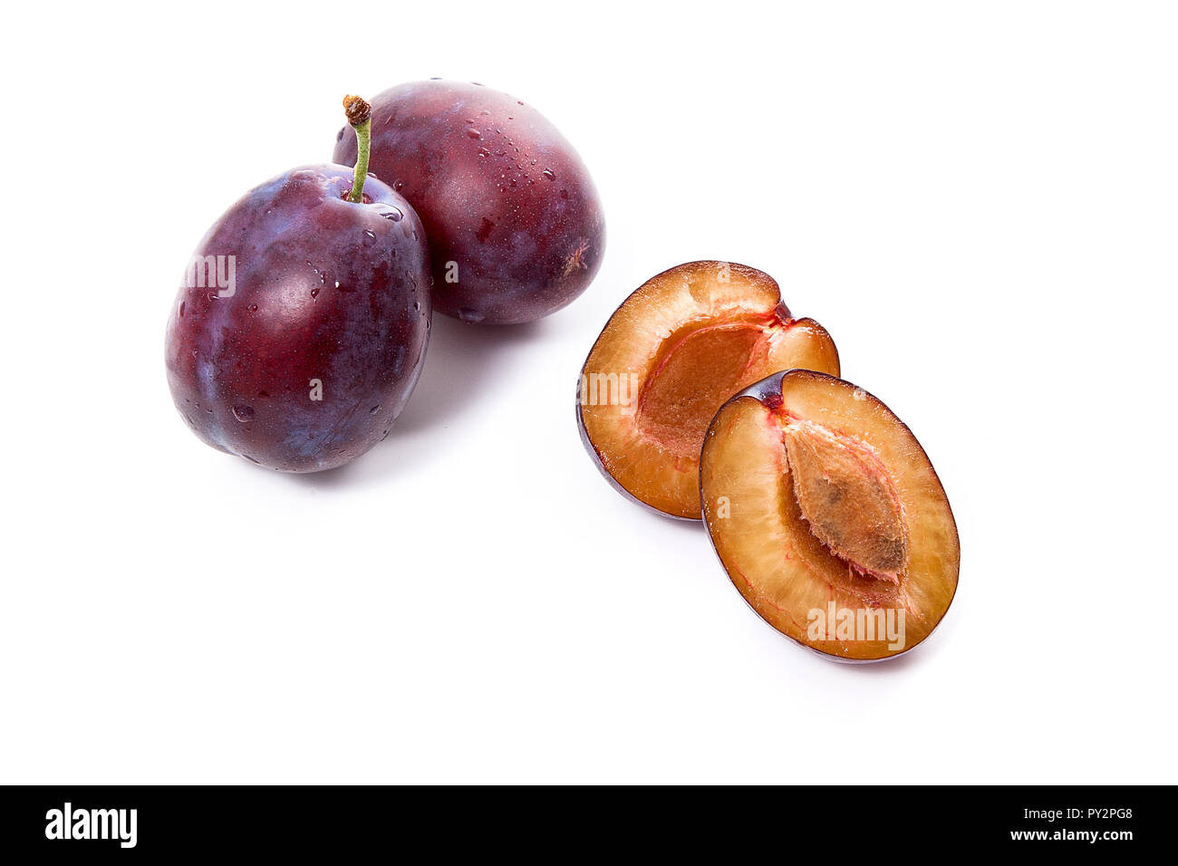 Two whole and half of sweet juicy plums isolated on a white background ...