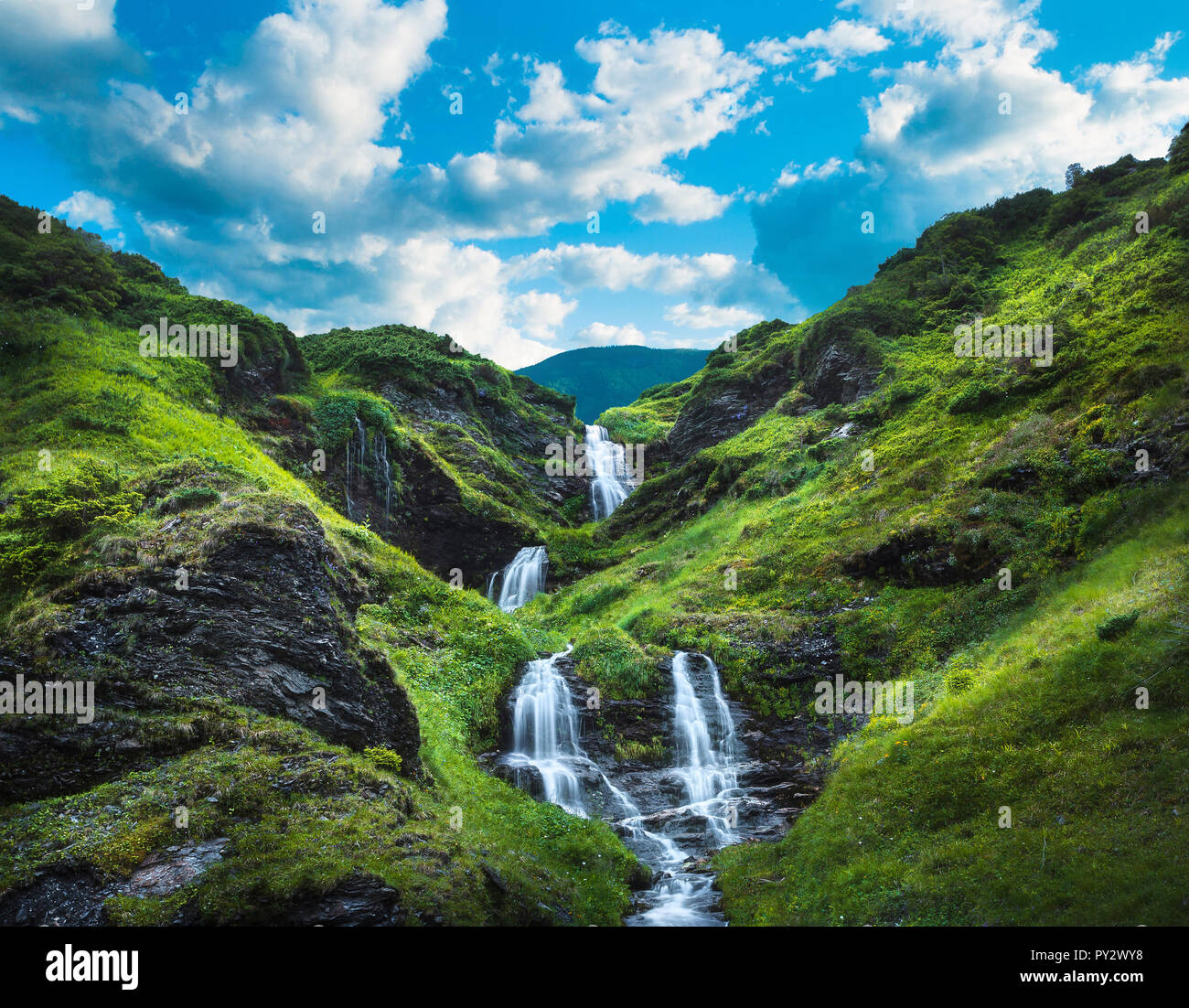 Waterfall, green hills and rolling clouds Stock Photo - Alamy
