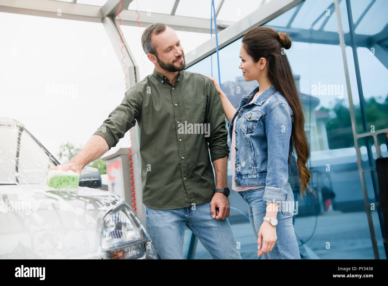 Young couple washing car together hi-res stock photography and images ...