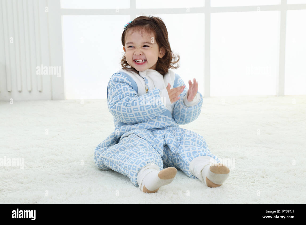 The little girl in a blue dress near a window. Portrait of the little ...