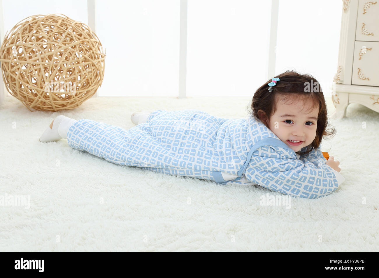 The little girl in a blue dress near a window. Portrait of the little ...