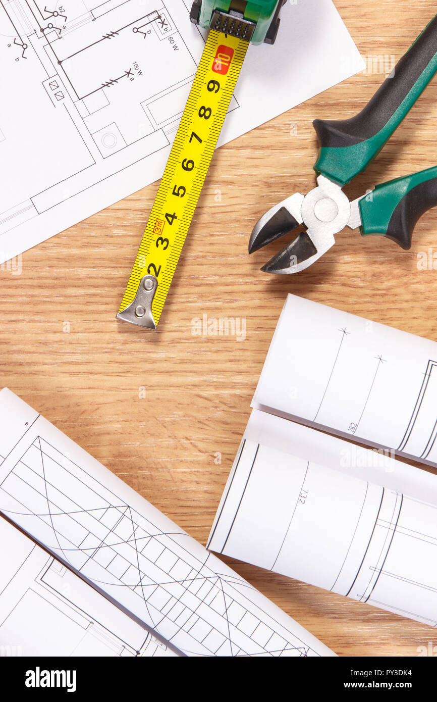 Rolls of blueprints or electrical construction drawings and work tools ...