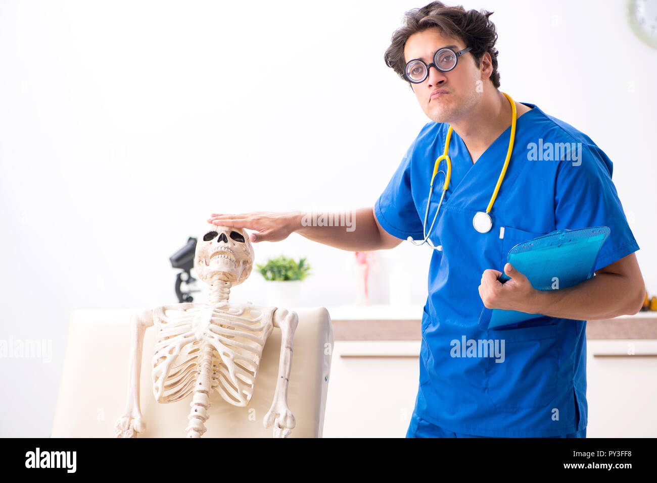 Funny doctor with skeleton in hospital Stock Photo - Alamy
