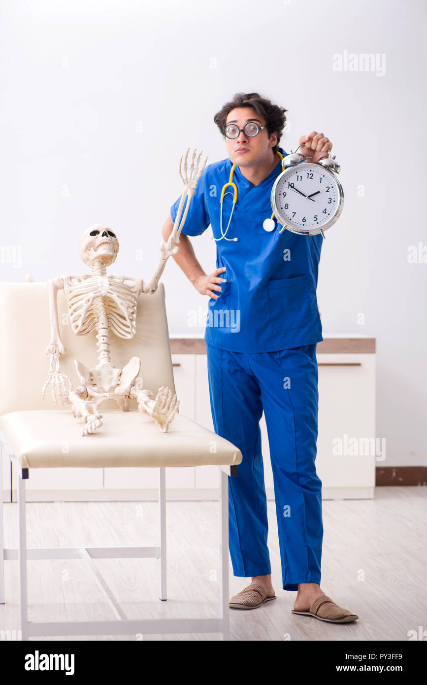 Funny doctor with skeleton in hospital Stock Photo - Alamy