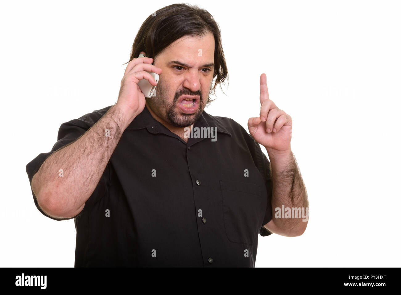 Angry fat Caucasian man talking on mobile phone while pointing f Stock ...