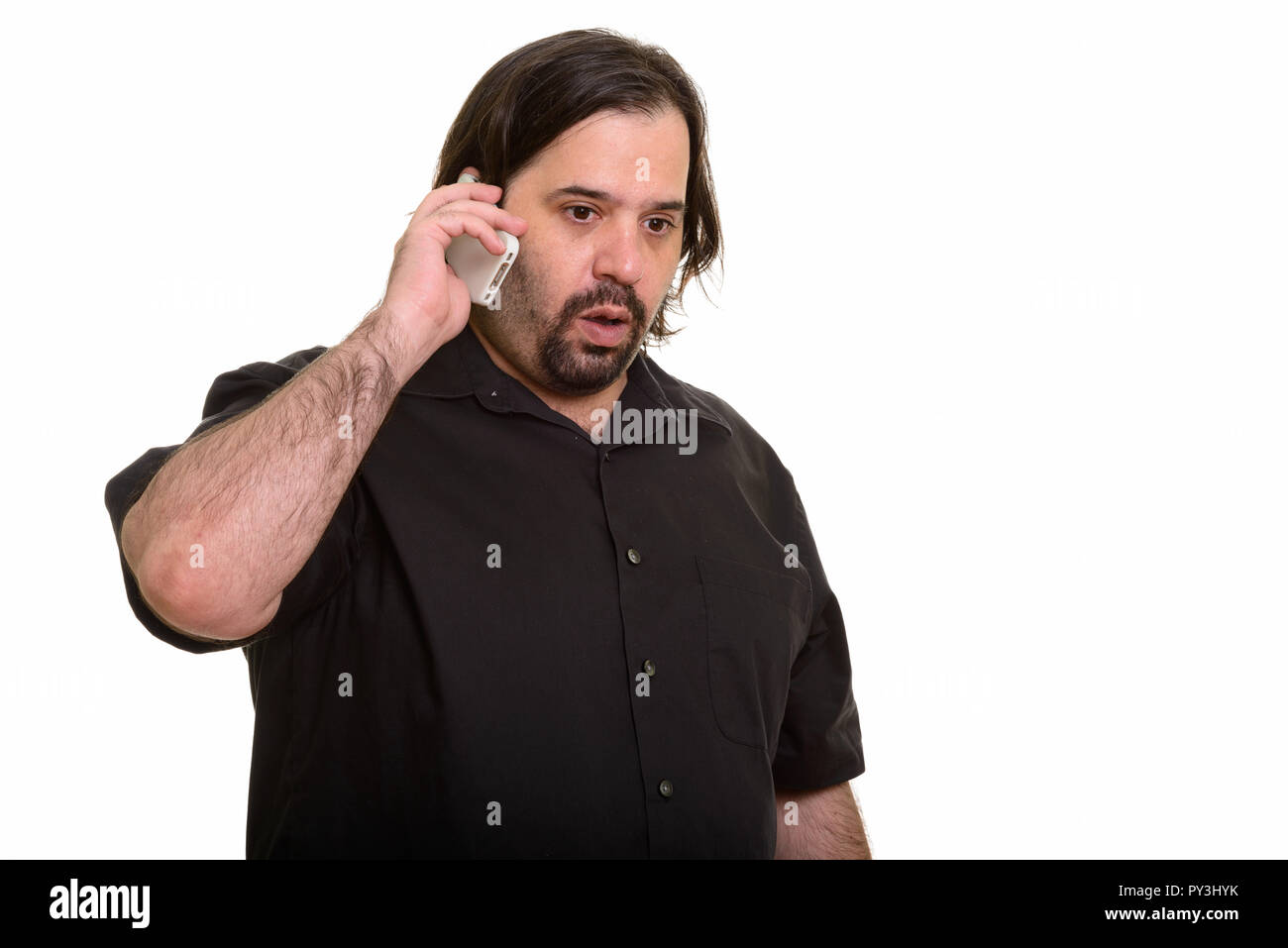 Fat Caucasian man looking shocked while talking on mobile phone Stock ...