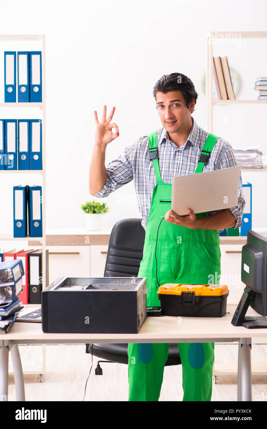 Young engineer repairing broken computer at the office Stock Photo - Alamy