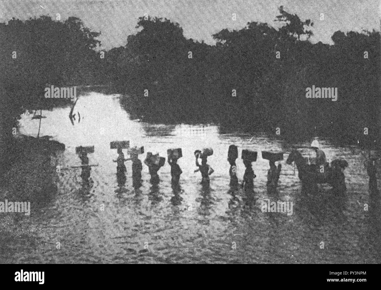 Cameroonian porters fording river Stock Photo - Alamy