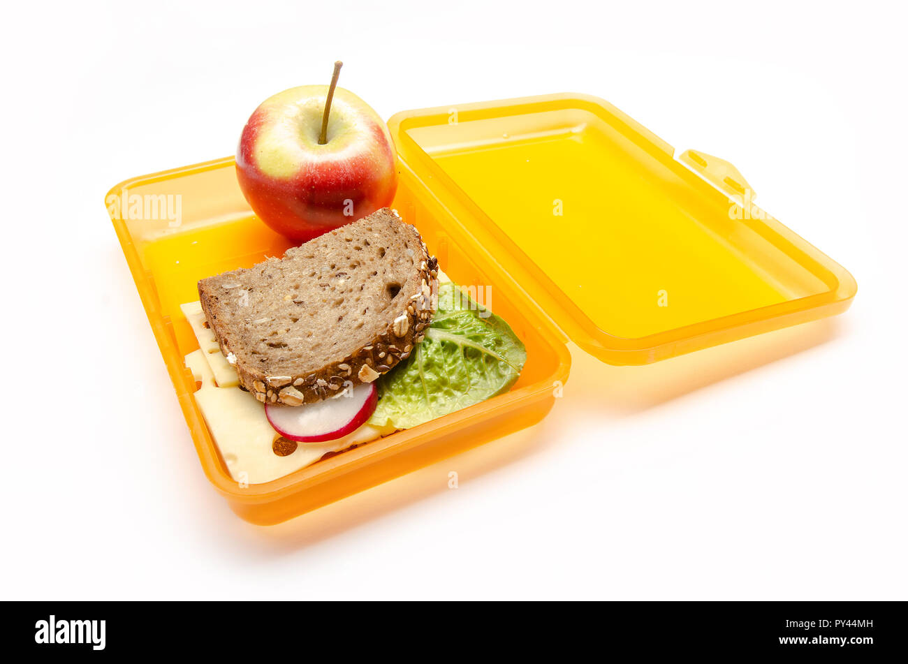 orange lunch box with bread and apple on white background, isolated ...
