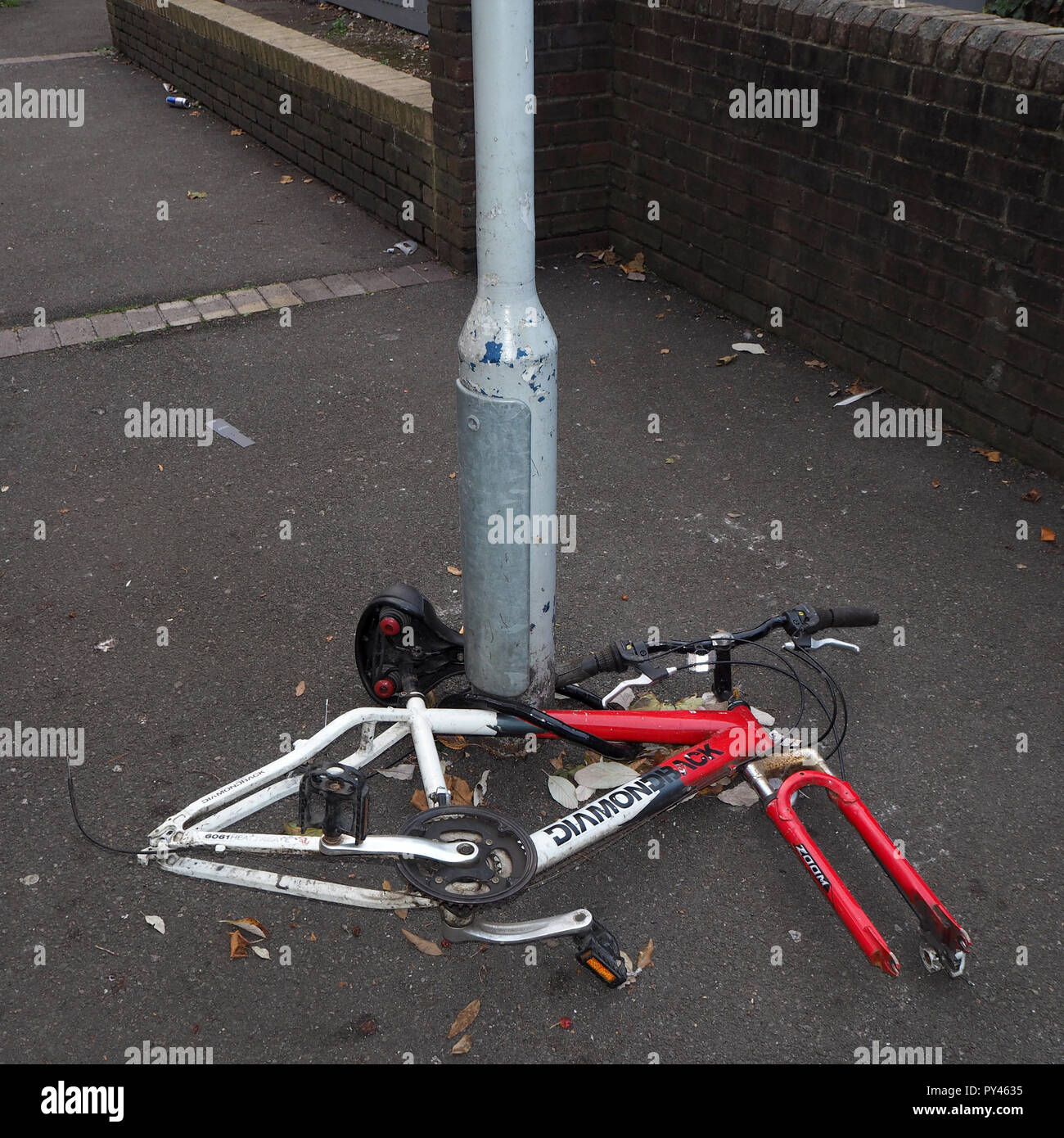 Damaged bicycle frame padlocked against lamp post Stock Photo - Alamy