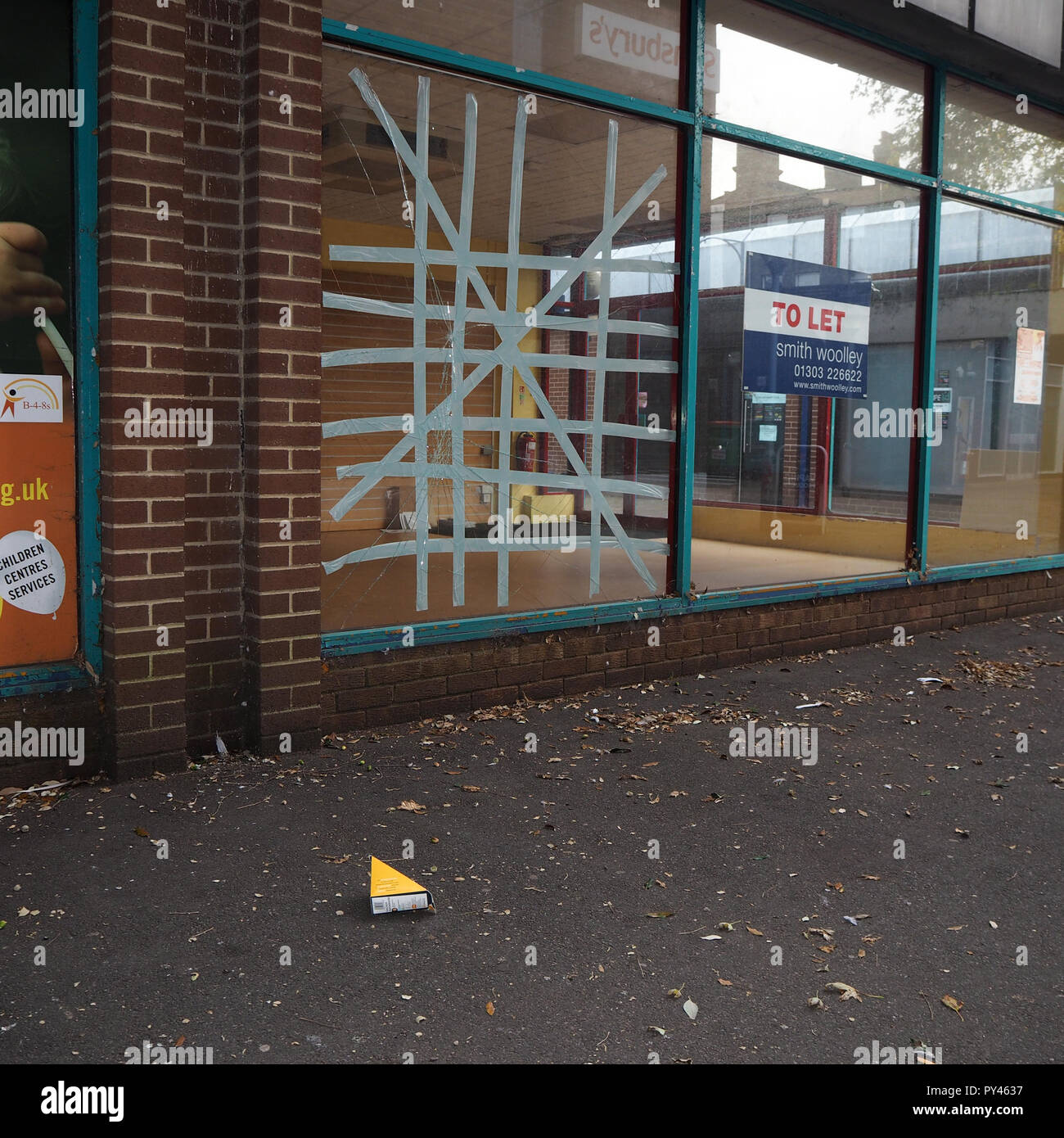 Taped up shattered shop window Stock Photo - Alamy