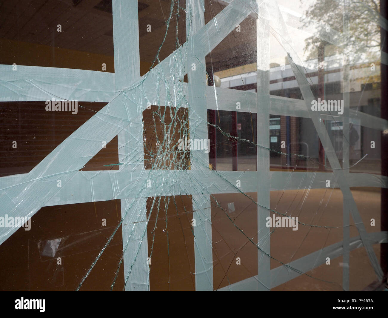 Taped up shattered shop window Stock Photo - Alamy
