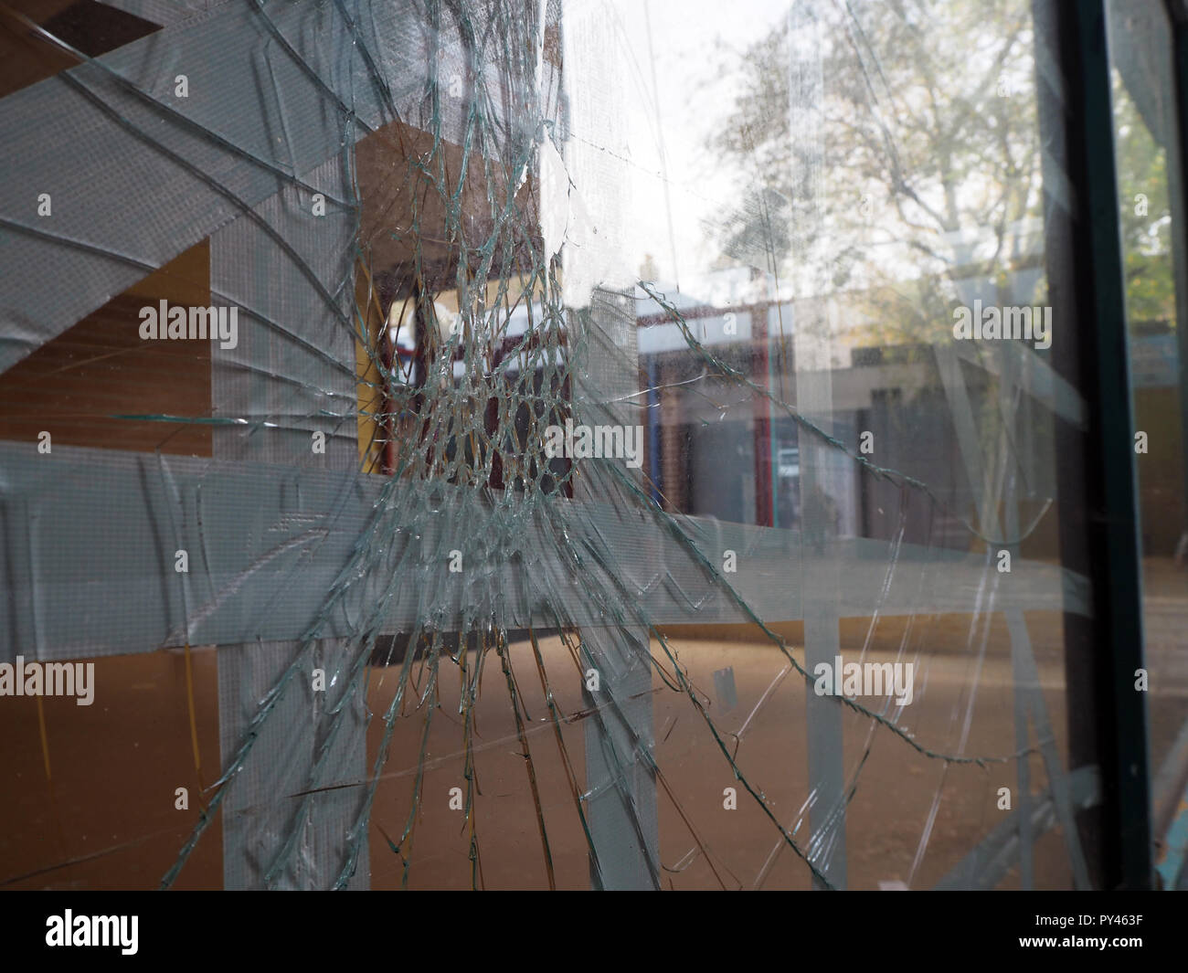 Taped up shattered shop window Stock Photo - Alamy