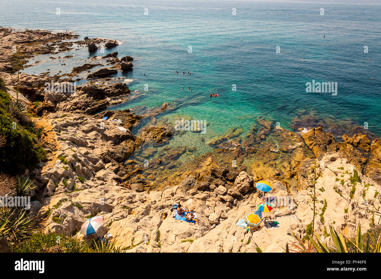 Rocky beach crystal clear water in Italian Riviera with colored beach ...