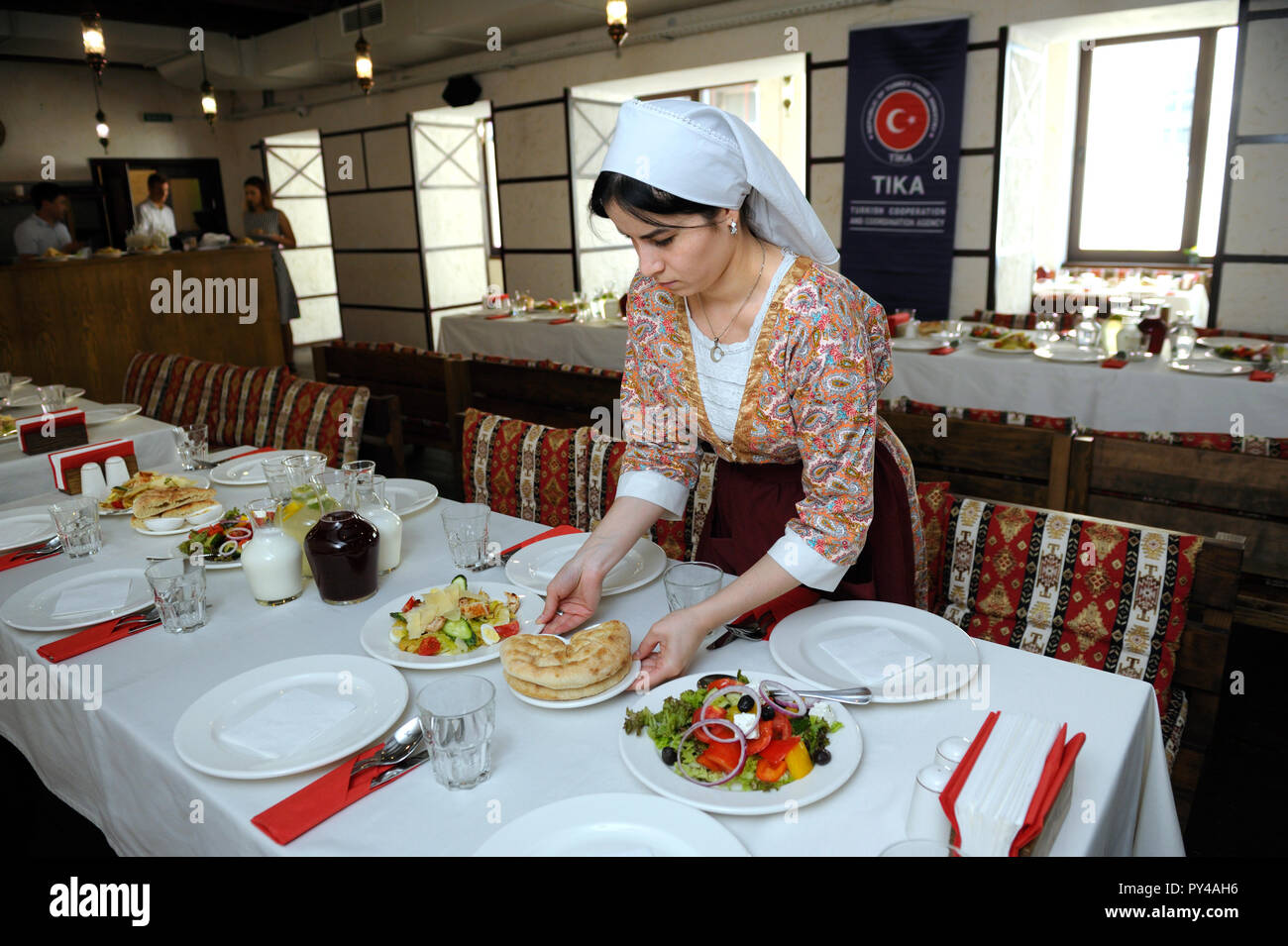 At the Tatar restaurant: waitress in Tatar native dress setting the ...