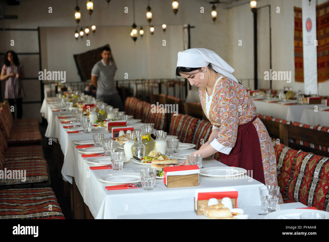 At the Tatar restaurant: waitress in Tatar native dress setting the ...