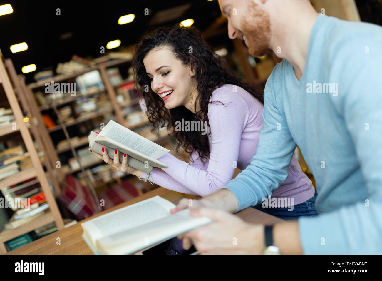 Young students spending time in coffee shop reading books Stock Photo ...