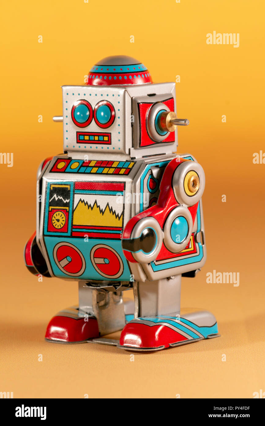 Vintage tin robot toy isolated on a yellow background Stock Photo - Alamy