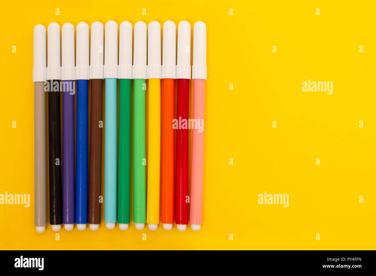 set of felt pens isolated on a yellow background Stock Photo - Alamy