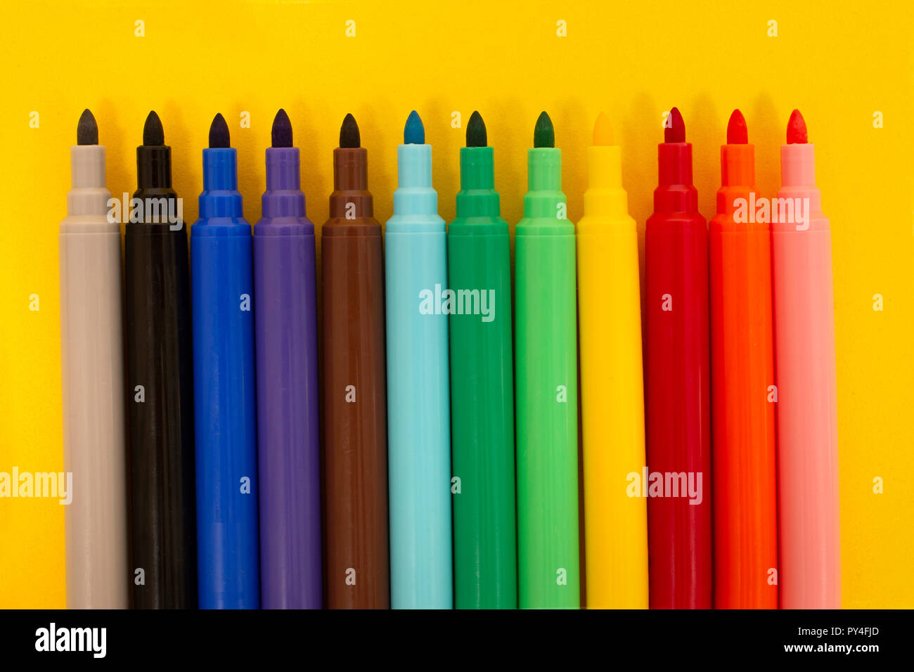 set of felt pens isolated on a yellow background Stock Photo - Alamy