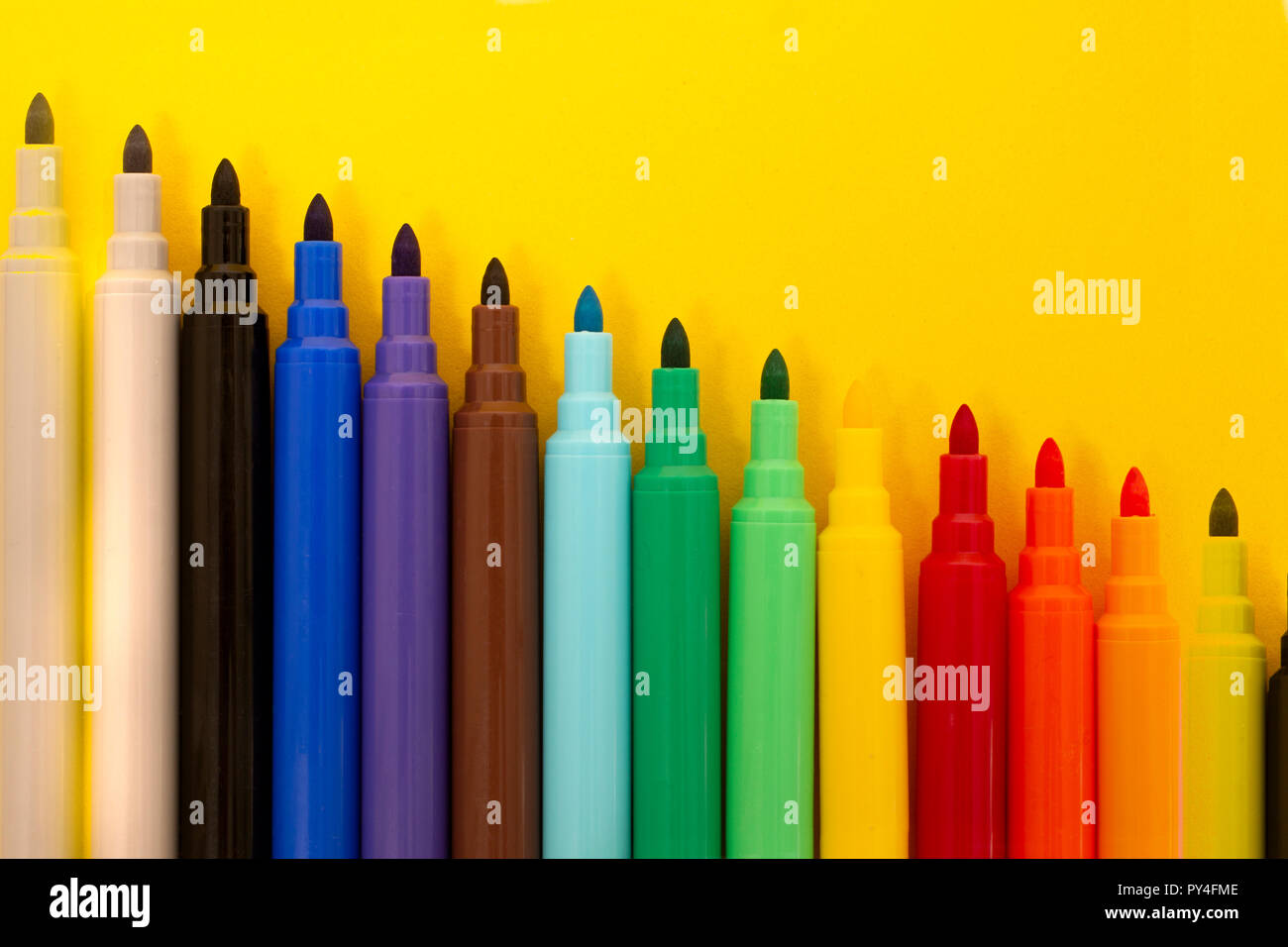 set of felt pens isolated on a yellow background Stock Photo - Alamy