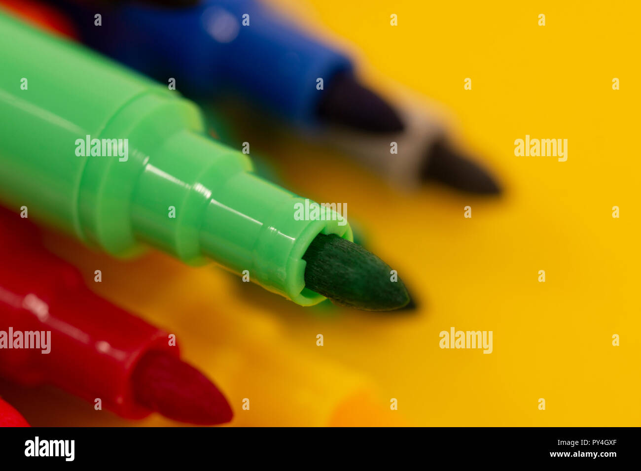 set of felt pens isolated on a yellow background Stock Photo - Alamy