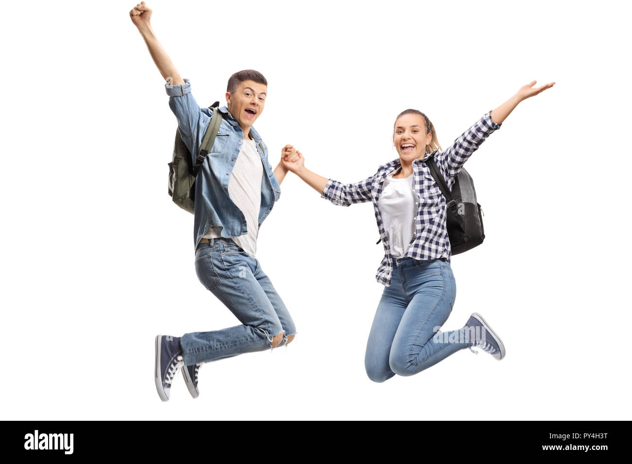 Happy male and female students jumping isolated on white background ...