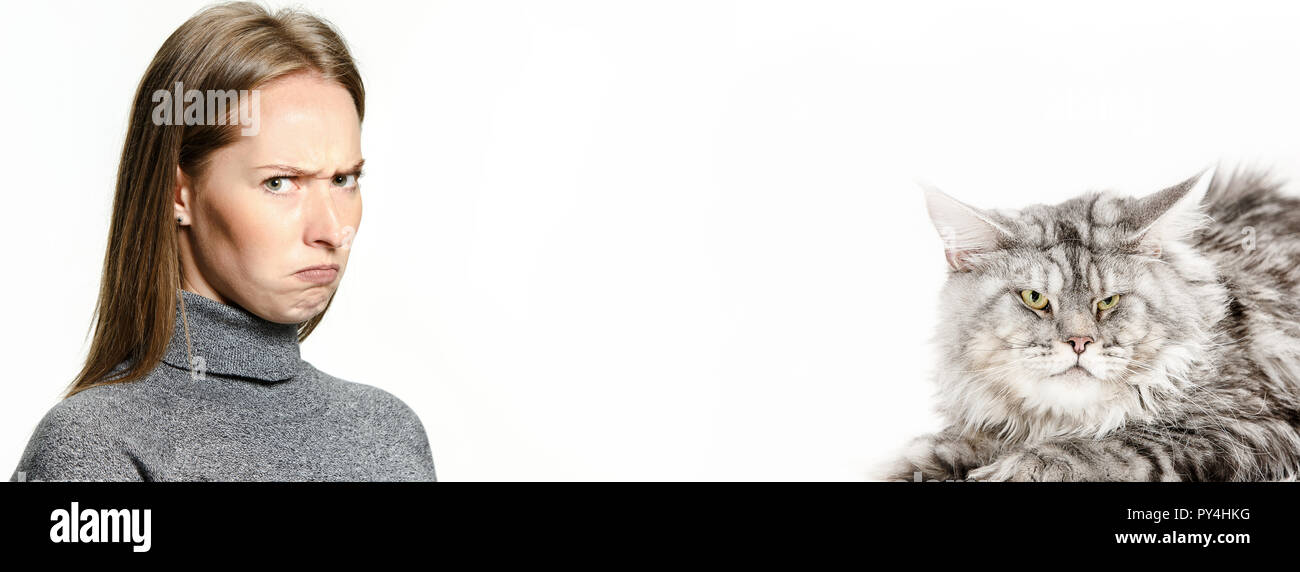 The angry and indignant woman and her cat over white background. The ...