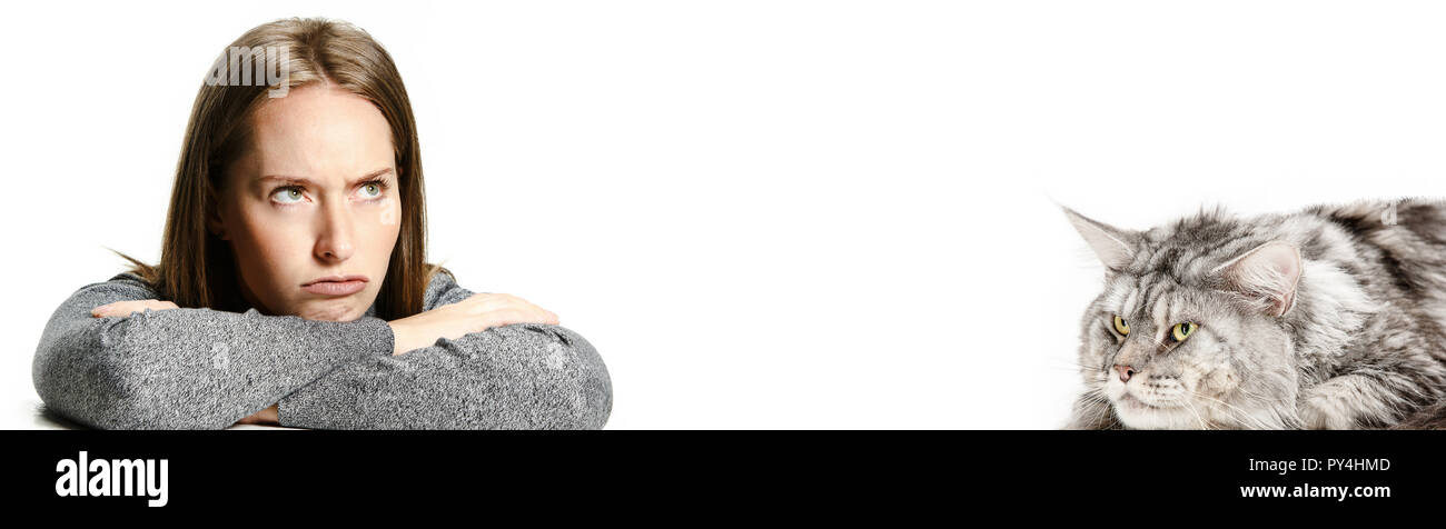 The angry and indignant woman and her cat over white background. The ...