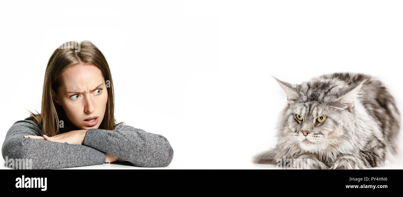The surprised and indignant woman and her cat over white background at ...