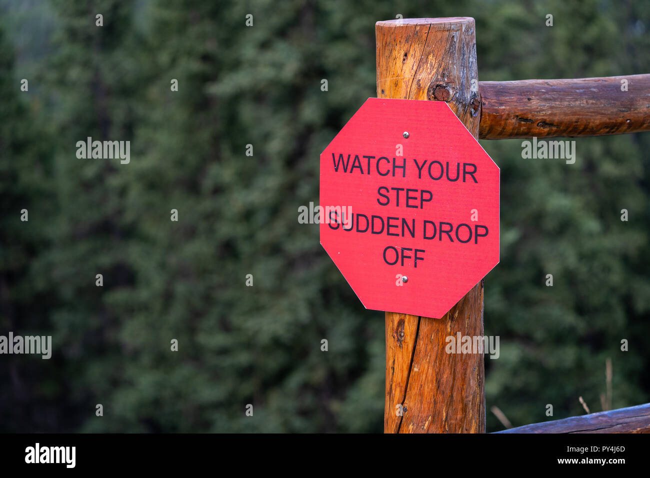 Sign post warns hikers and pedestrians to Watch Your Step Sudden Drop ...
