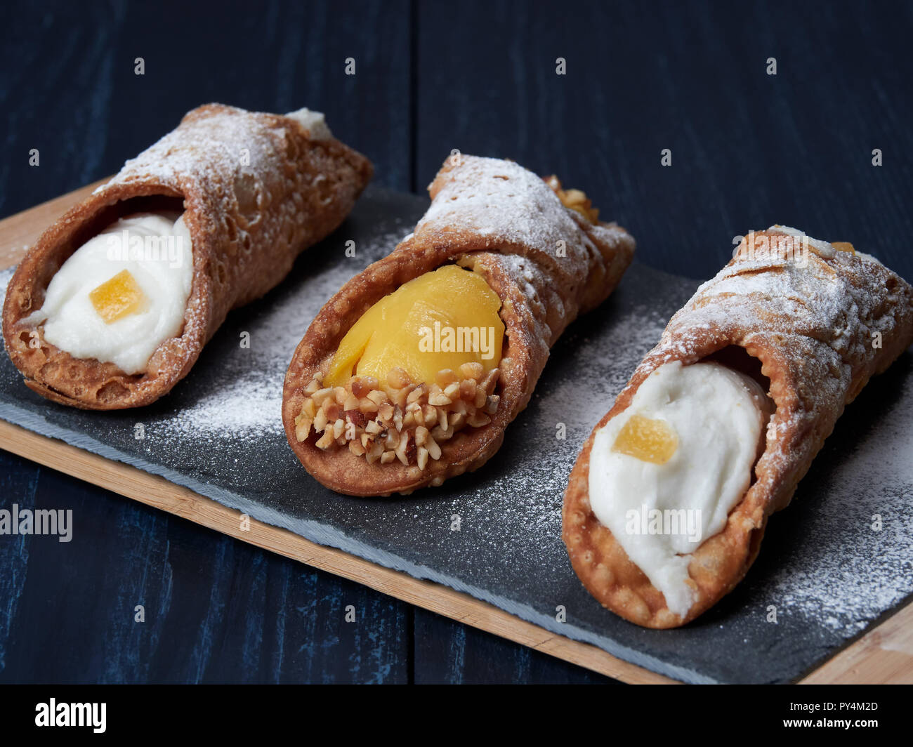 Cannoli pastries on a slate, a traditional Sicilian dessert made of ...