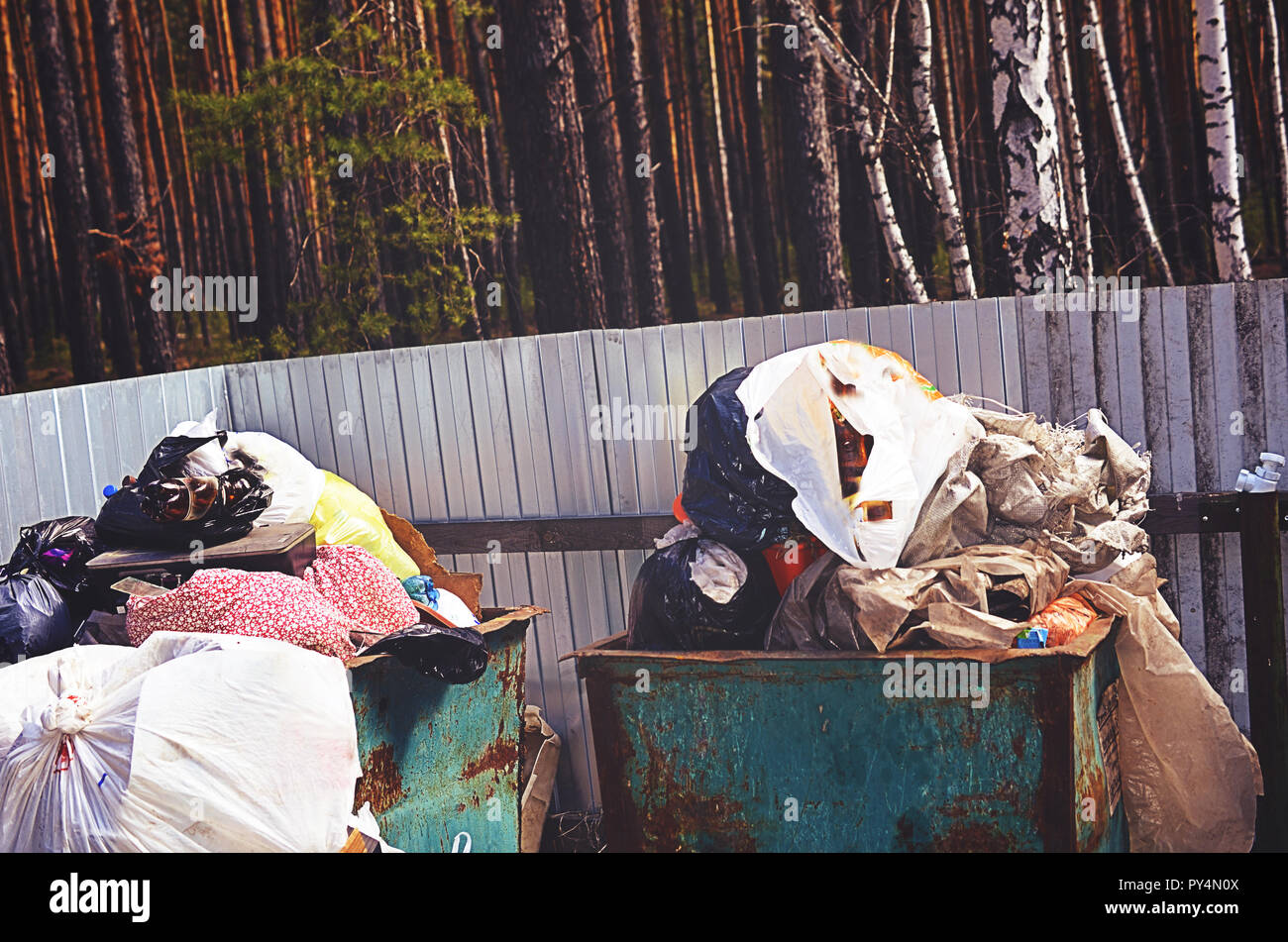 Litter box full of garbage in forest. Concept of ecology problem. Toned ...