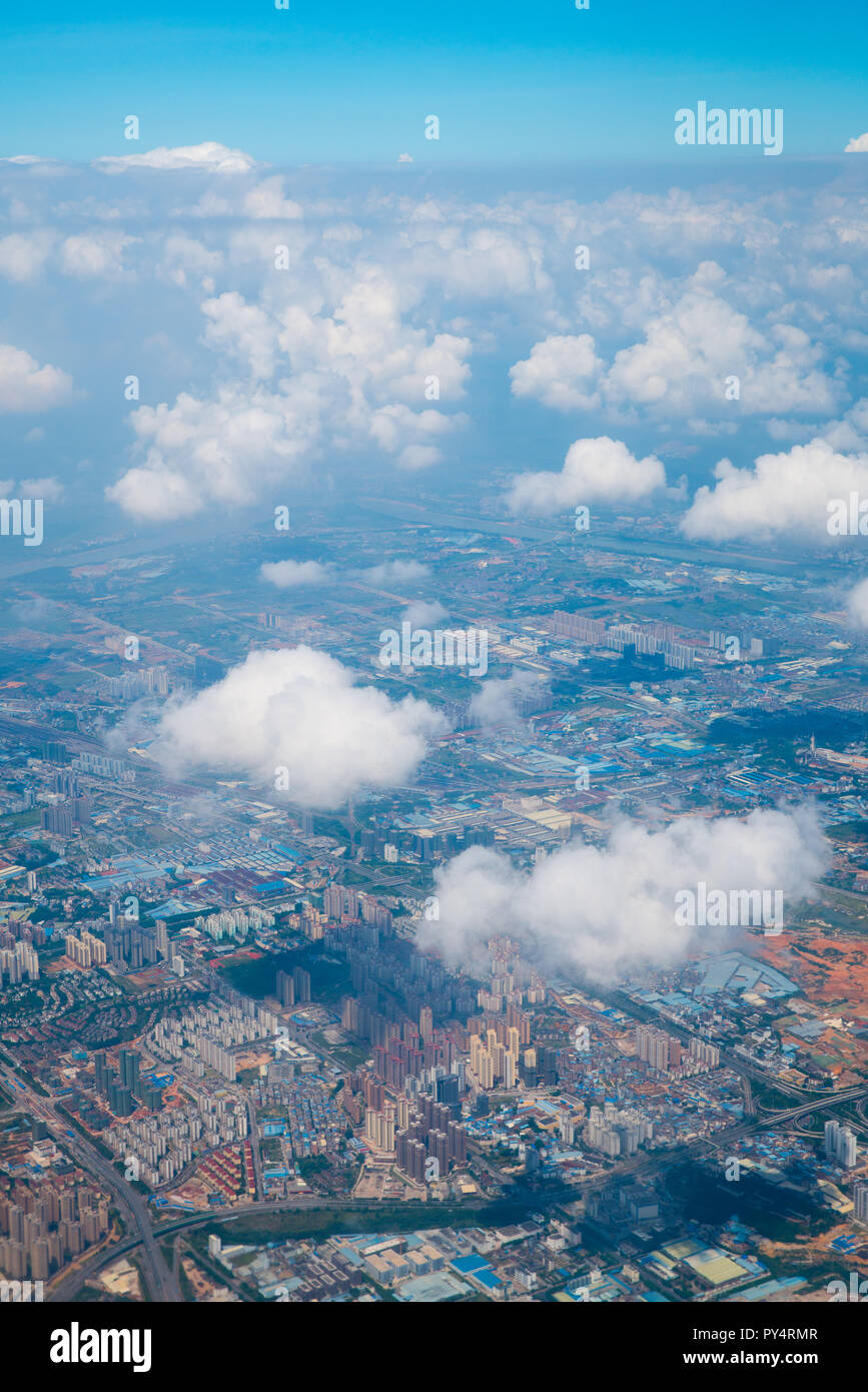 aerial view, flying above the puffy white clouds and over ground ...