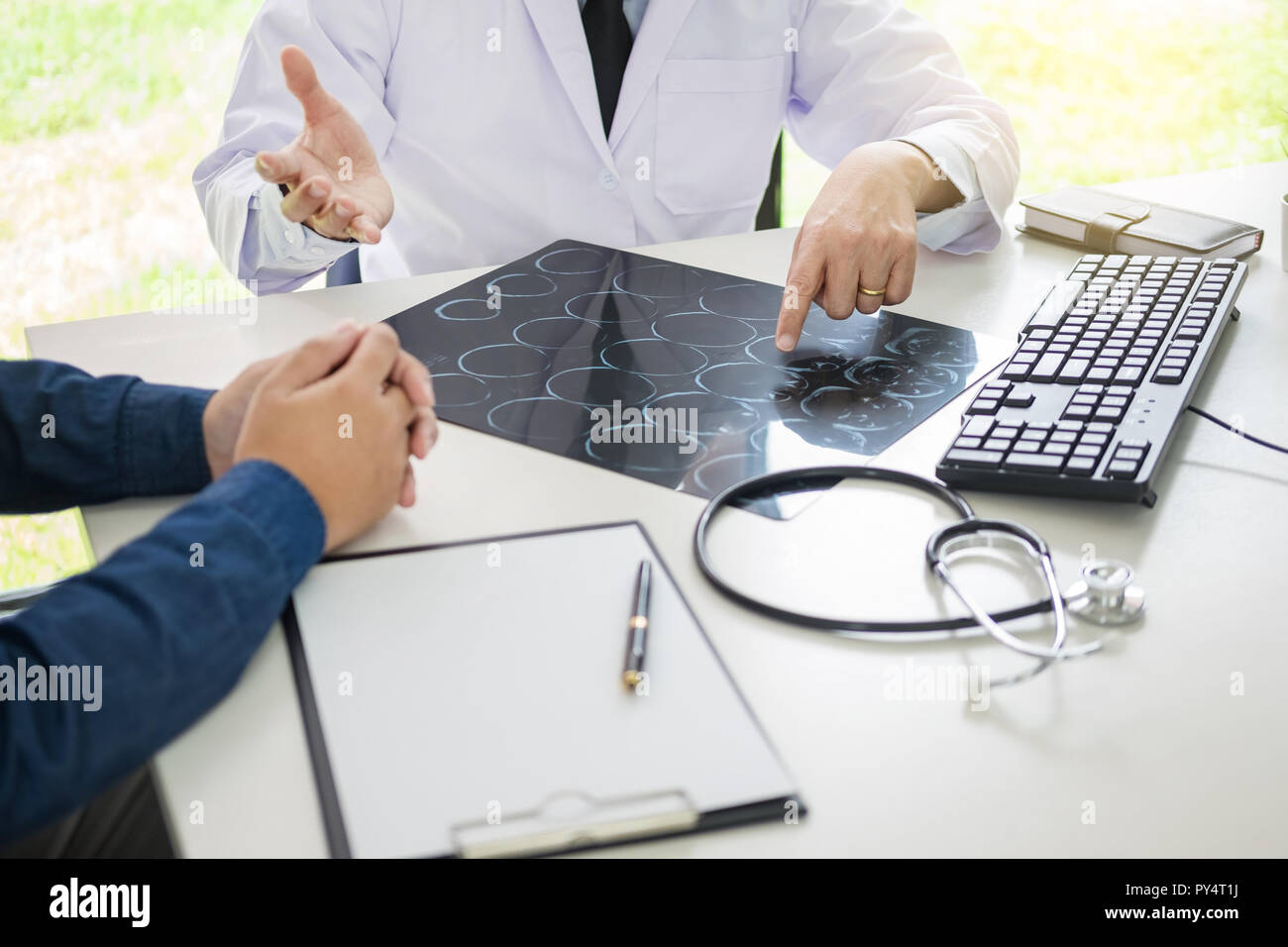 doctor analyzing a scan or x-ray film or explains a CT scan thoughtful ...