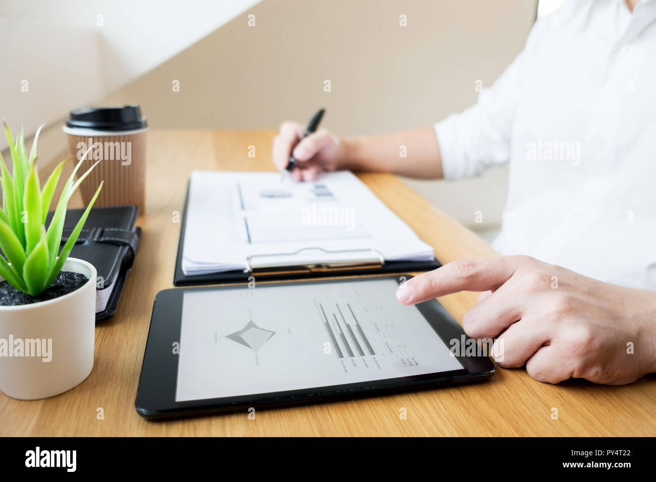 businessman going through some paperwork and signing a document at desk ...