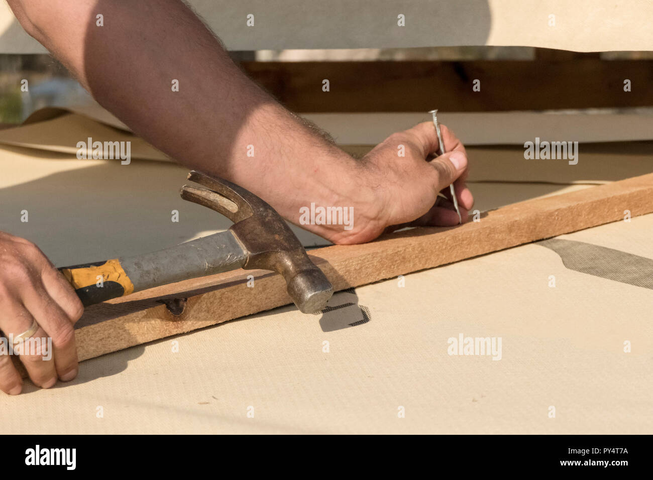 Roof construction building. Man hammering nails in to construction ...