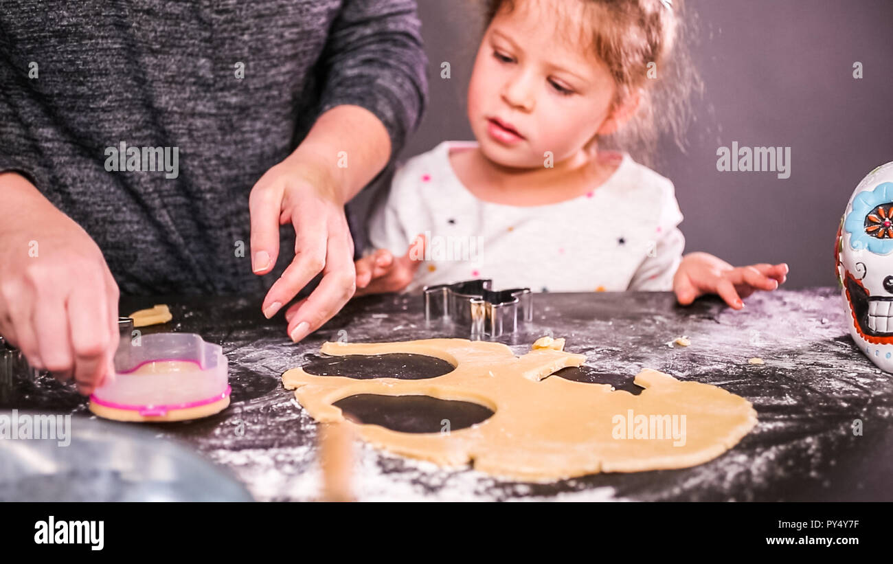 Mother and daughter baking sugar skull cookies for Dia de los Muertos ...