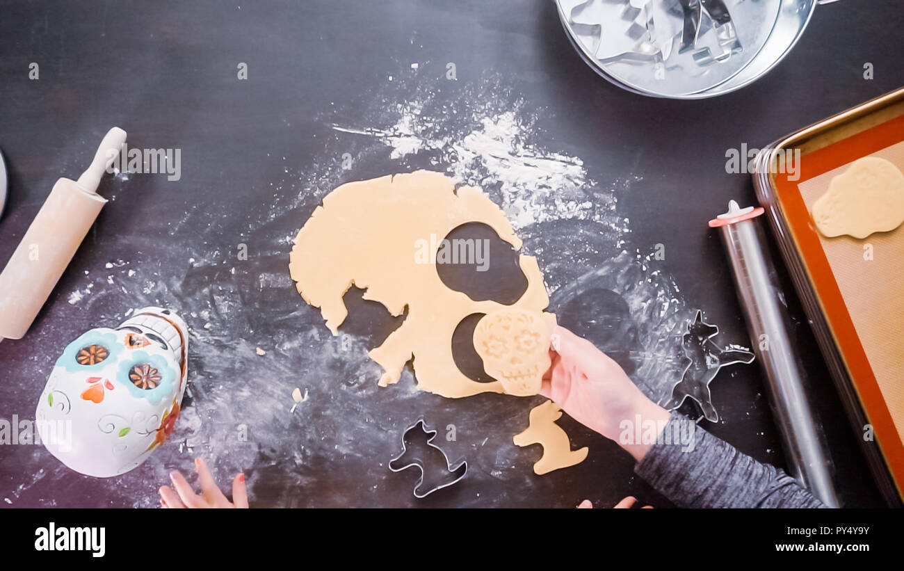 Flat lay. Mother and daughter baking sugar skull cookies for Dia de los ...