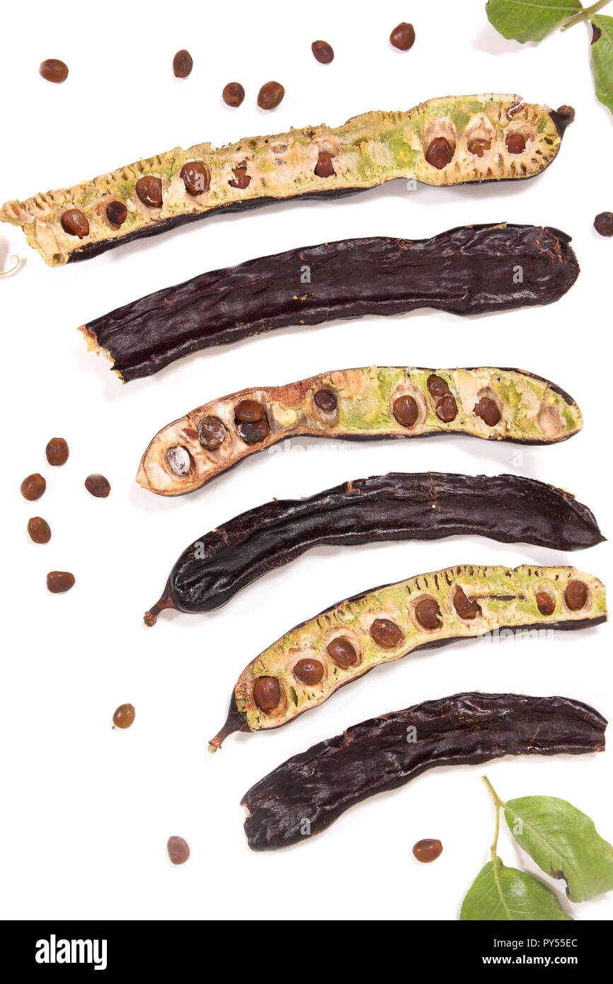 carob fruits with leafs isolated over a white background Stock Photo ...