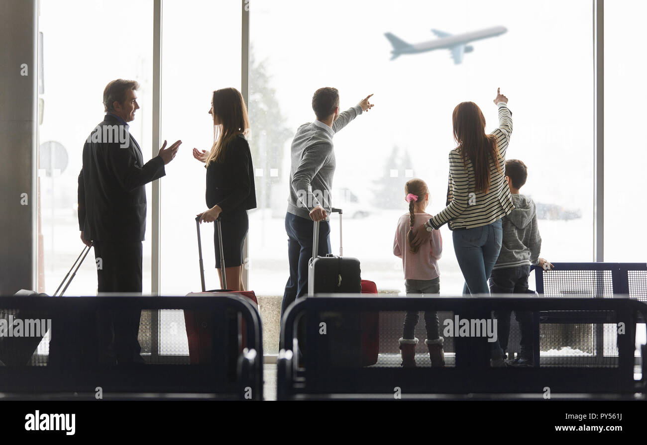 Group of travelers while waiting at the airport terminal in front of a ...