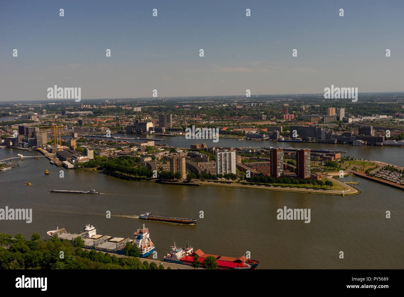 Netherlands, Rotterdam, a small boat in a body of water with a city ...