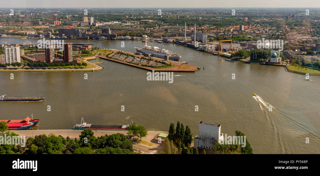 Netherlands, Rotterdam, a small boat in a body of water with a city ...